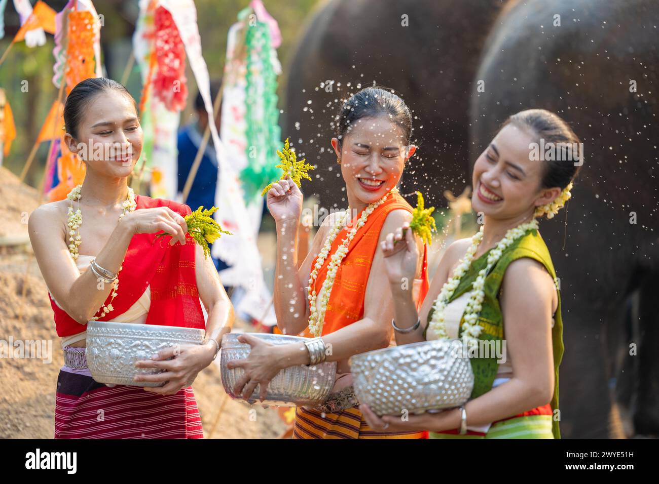 Songkran festival. Northern Thai people in Traditional clothes dressing splashing water together ...