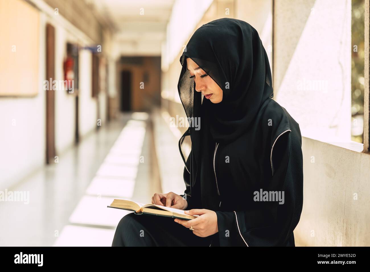 Young teen muslim niqab woman reading the Quran and faith The Holy Al ...