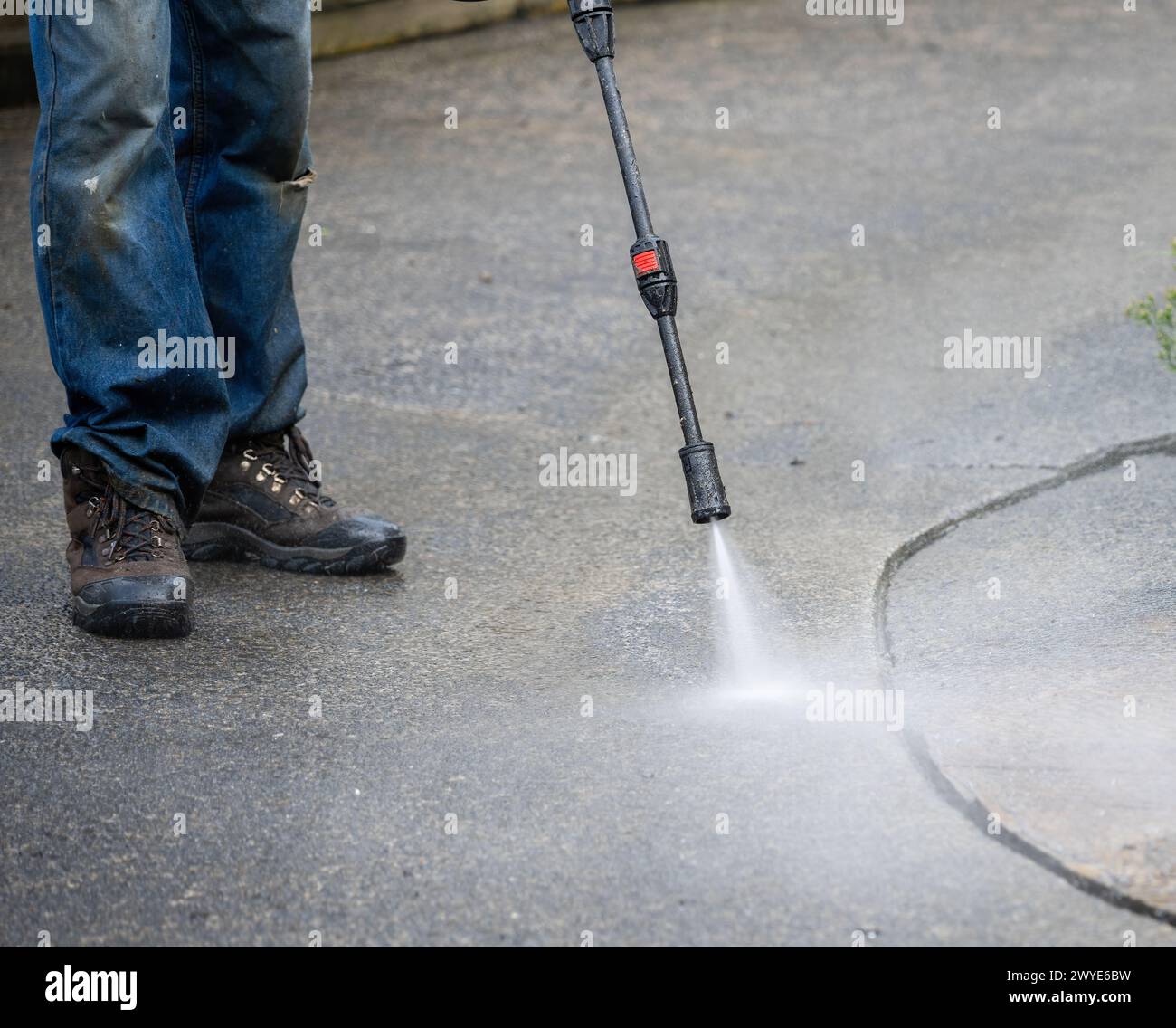 Worker cleaning pavement using an electric water blaster Stock Photo ...