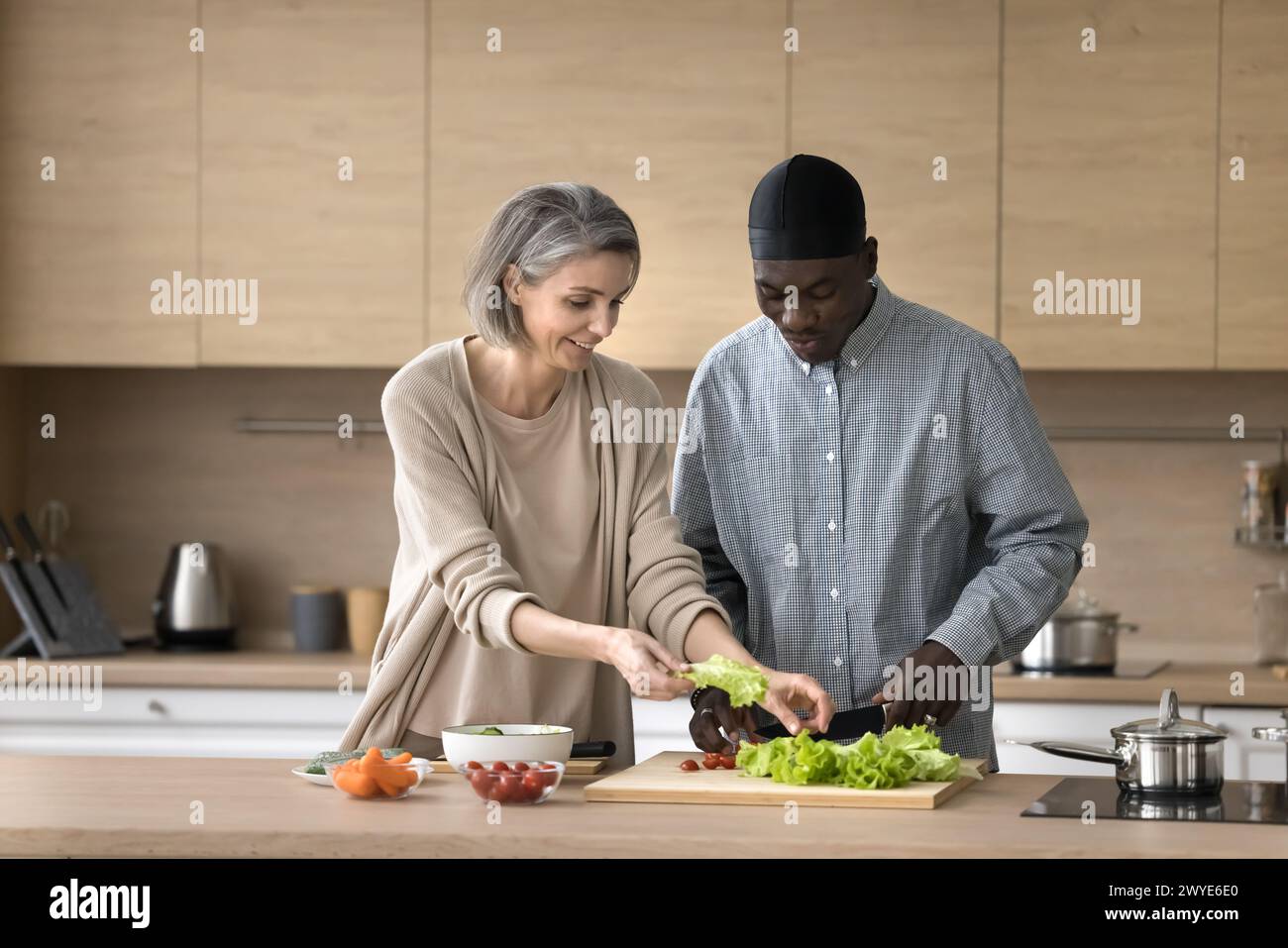 Happy multiethnic couple prepare vegetable salad together Stock Photo ...