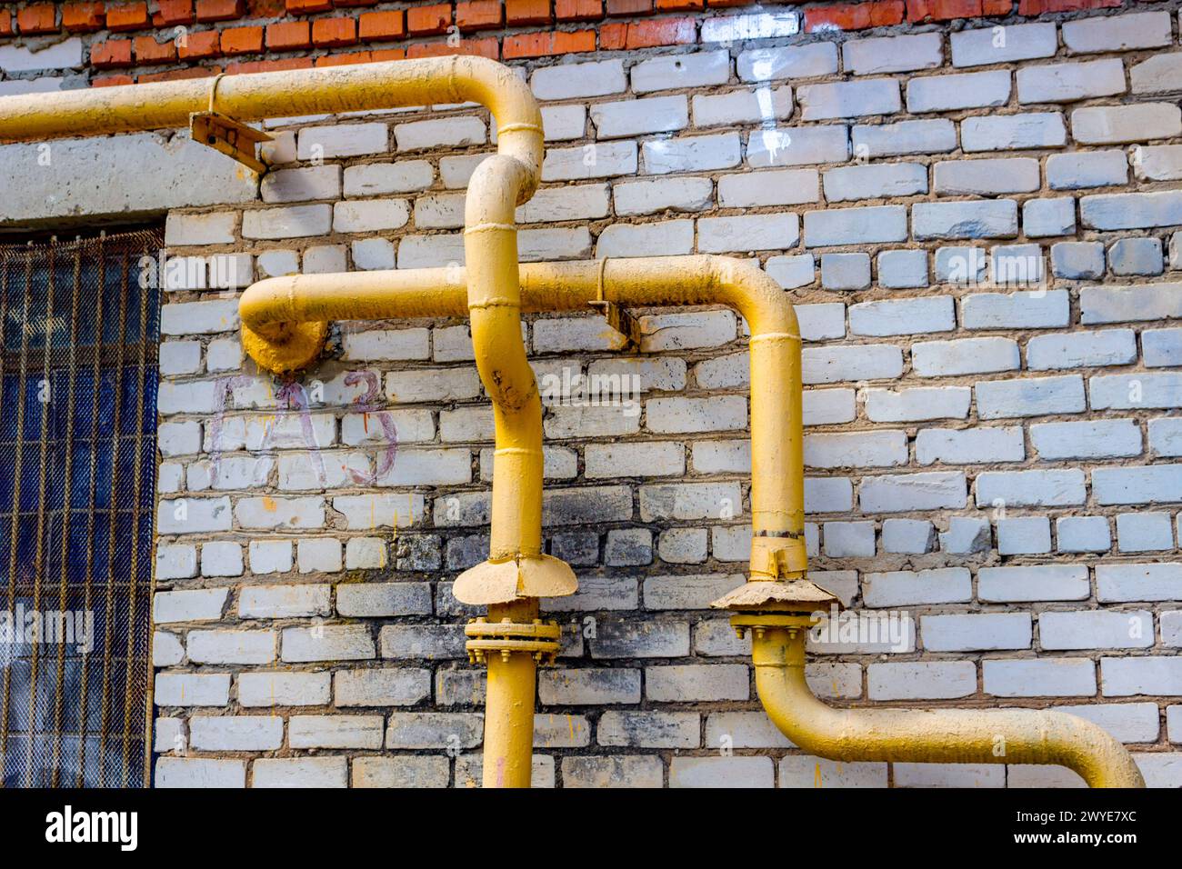 Yellow gas pipes on the wall facade Stock Photo - Alamy