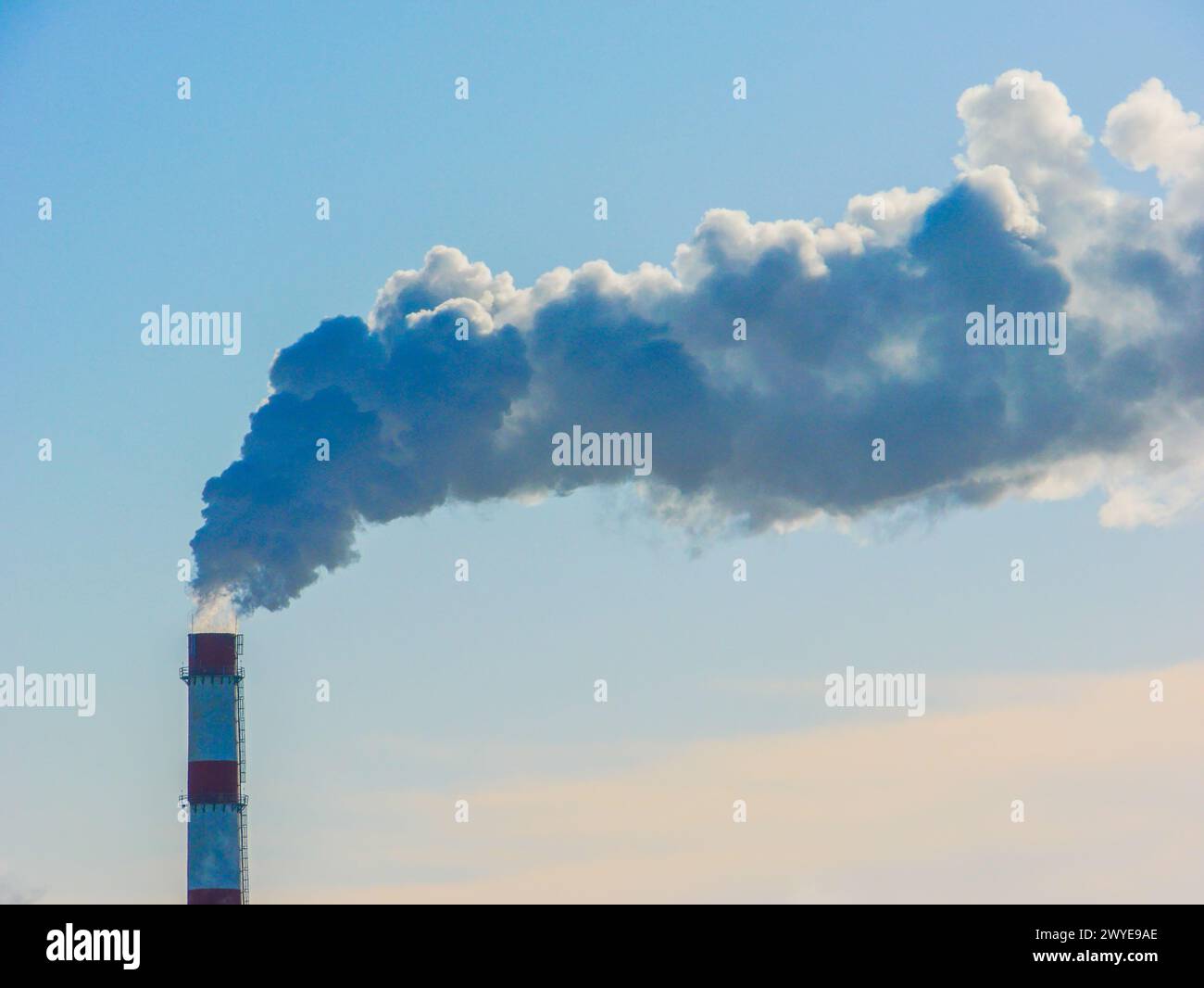 High chimney with thick smoke on the background of the sky.Factory ...