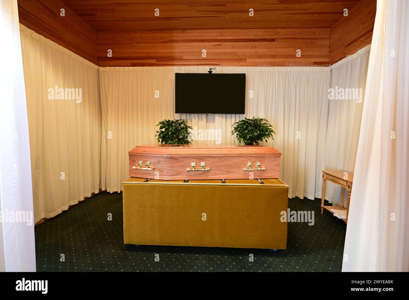 Coffin in a funeral chapel with the morning sun providing illumination ...