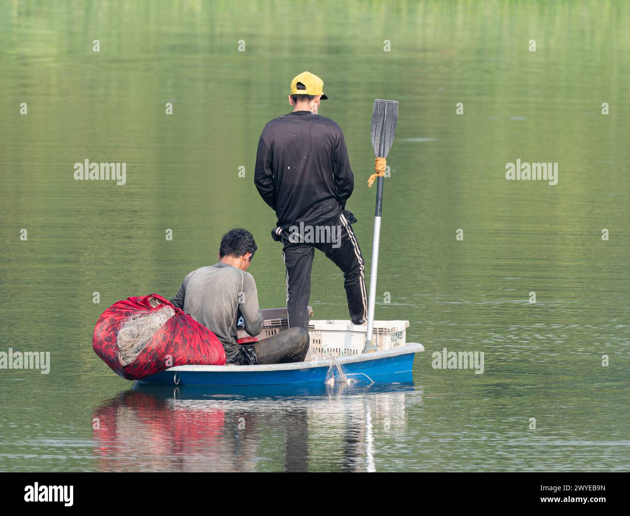fisher man fishing in the water with help of small fishing boat and ...
