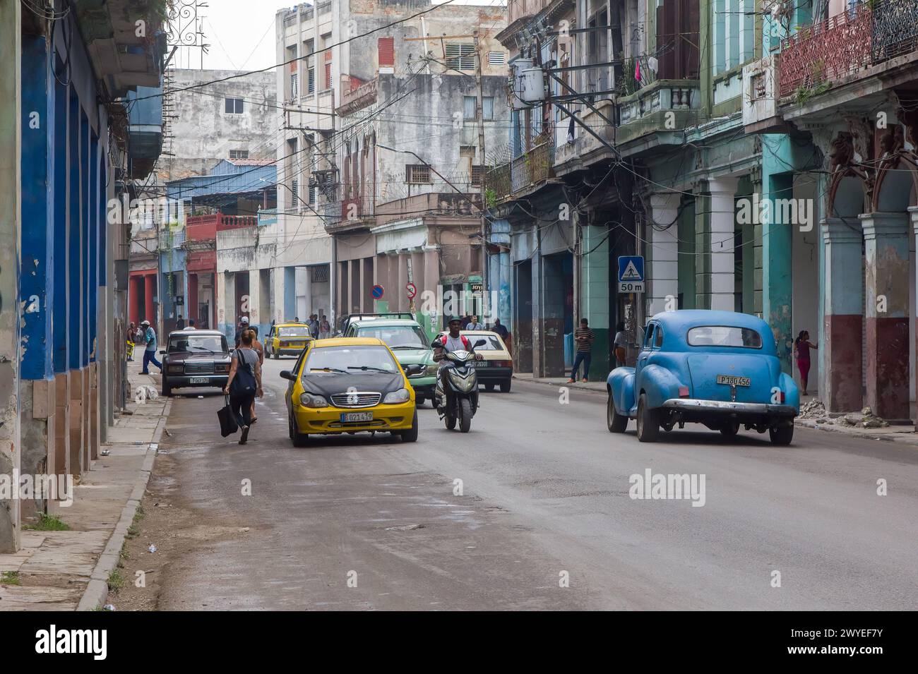 Traffic and Cuban people by weathered buildings in Havana, Cuba Stock ...