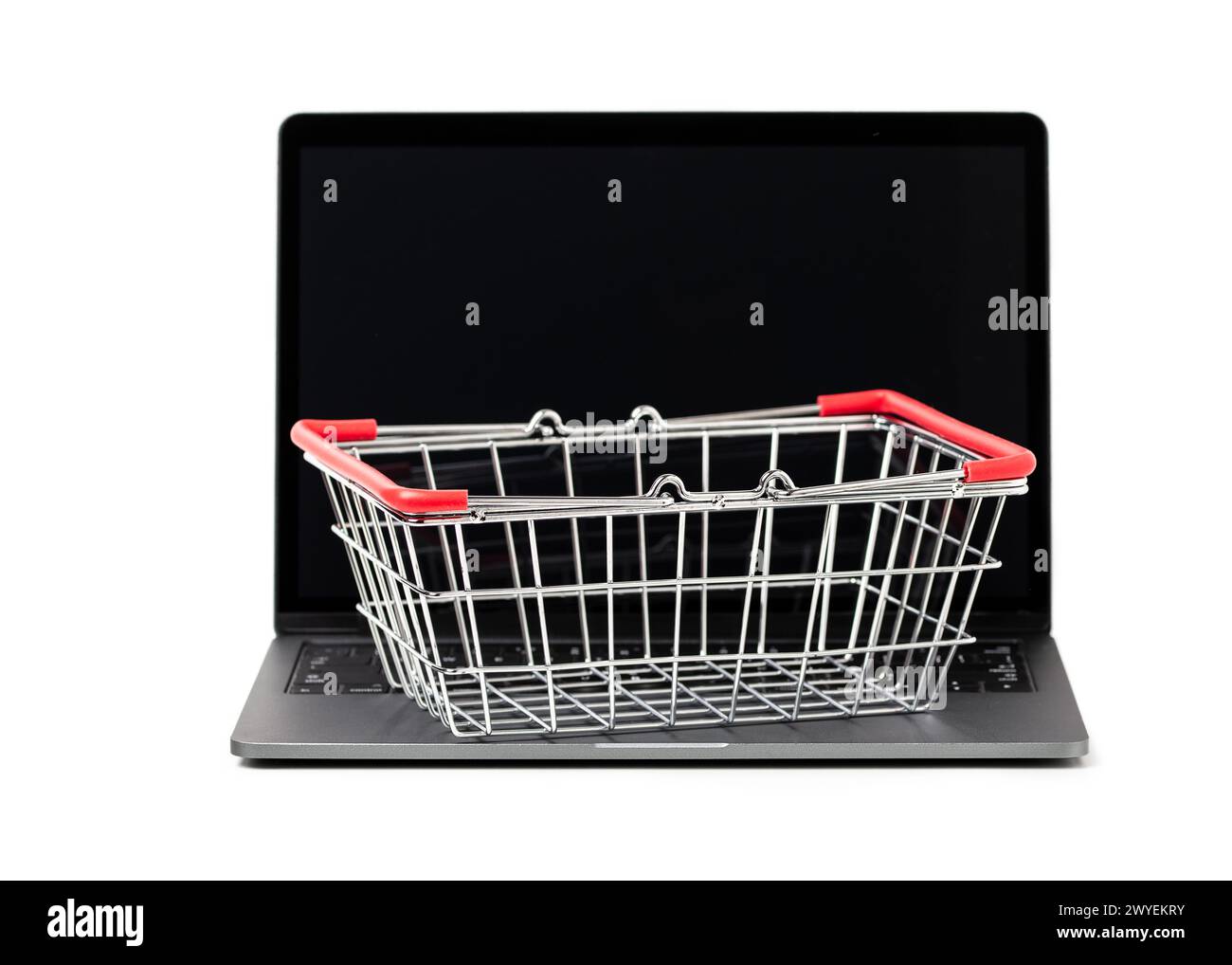 Online shopping concept. Shopping basket, empty and laptop on the desk ...