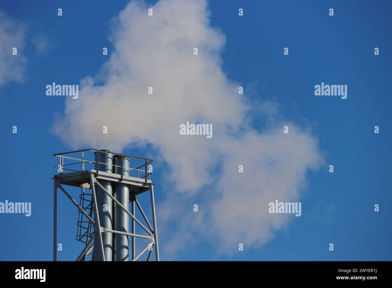 A metal pipe with white smoke coming from it. Factory smoke causes ...