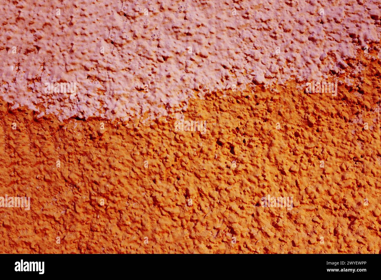 Old plaster painted in two different colors. Orange and pink color of ...