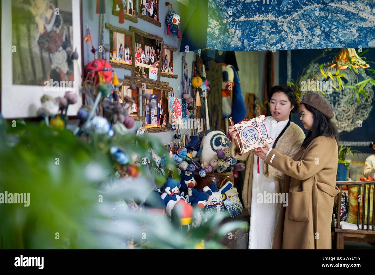 (240406) -- HEBEI, April 6, 2024 (Xinhua) -- Li Sa (L) introduces a batik product to a customer ...