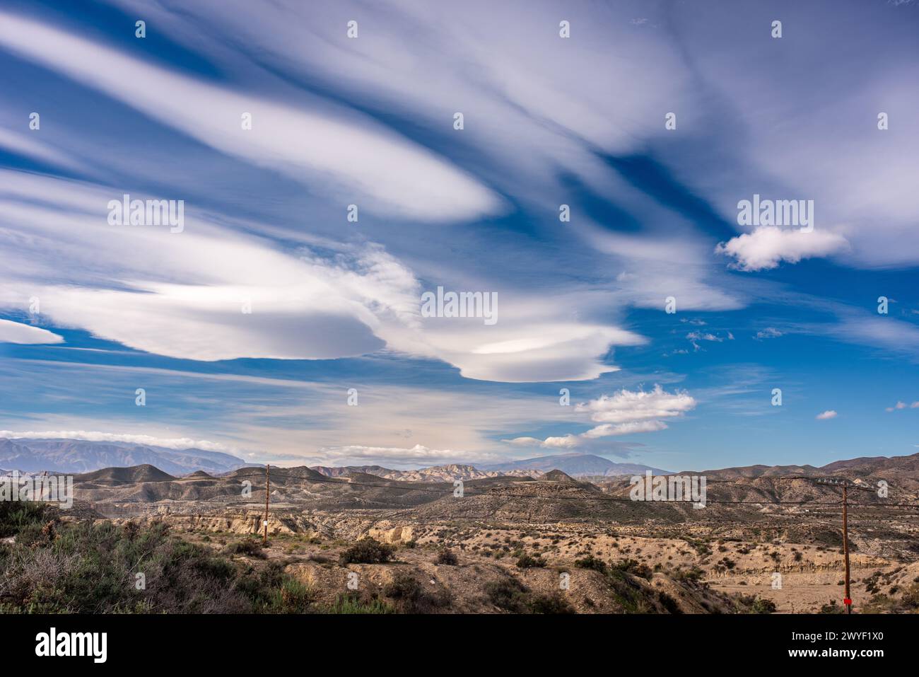 Streaked clouds stretch across the sky above the arid terrain of ...