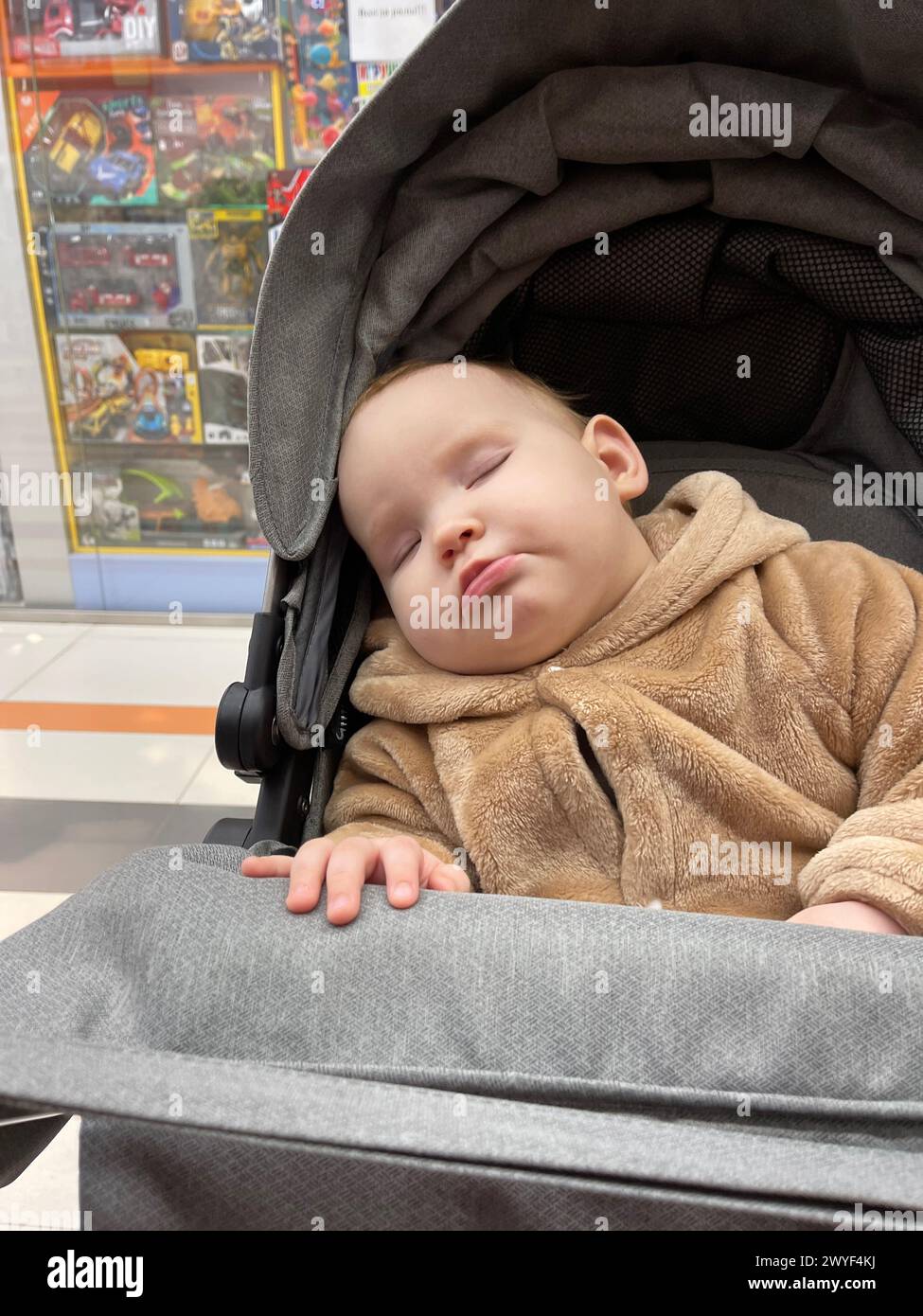 A sleeping child in a cozy stroller, undisturbed by the surrounding ...