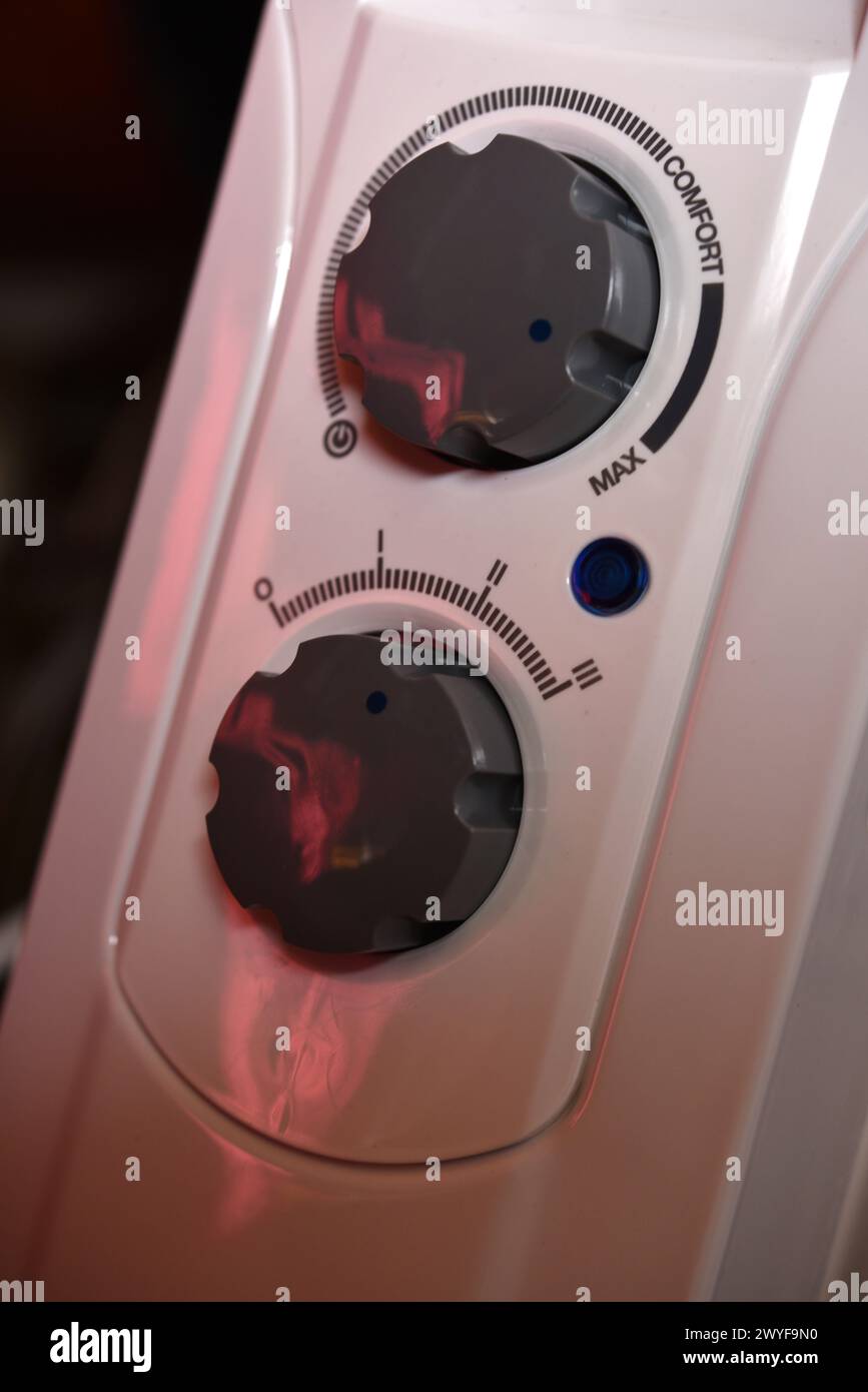 Round switches on a white radiator. The control panel Stock Photo - Alamy