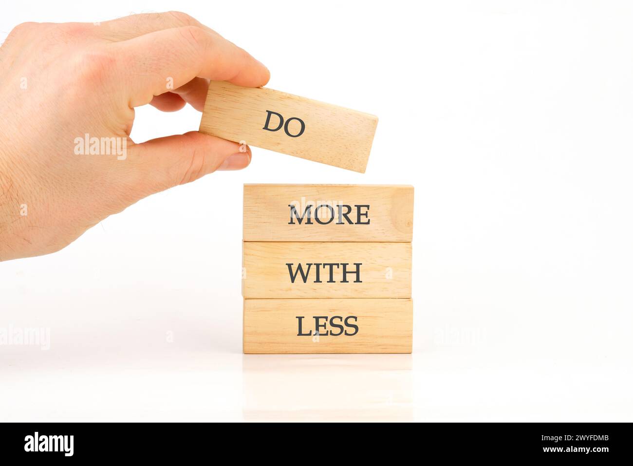 DO MORE WITH LESS on wooden blocks assembled by hand Stock Photo - Alamy