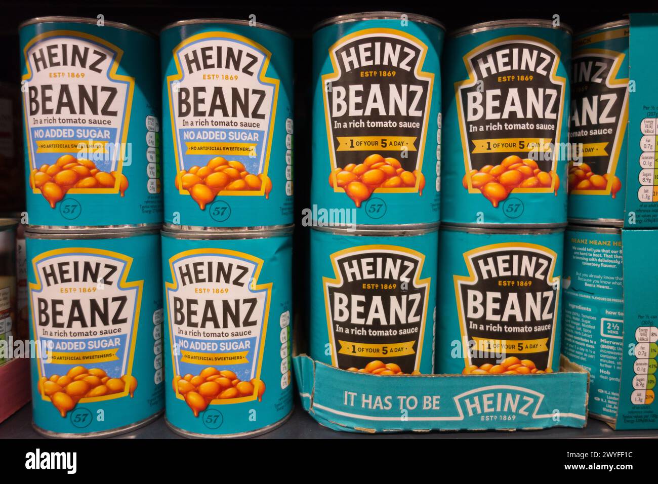Closeup of tins of Heinz Baked Beans on a supermarket shelf, England, U ...