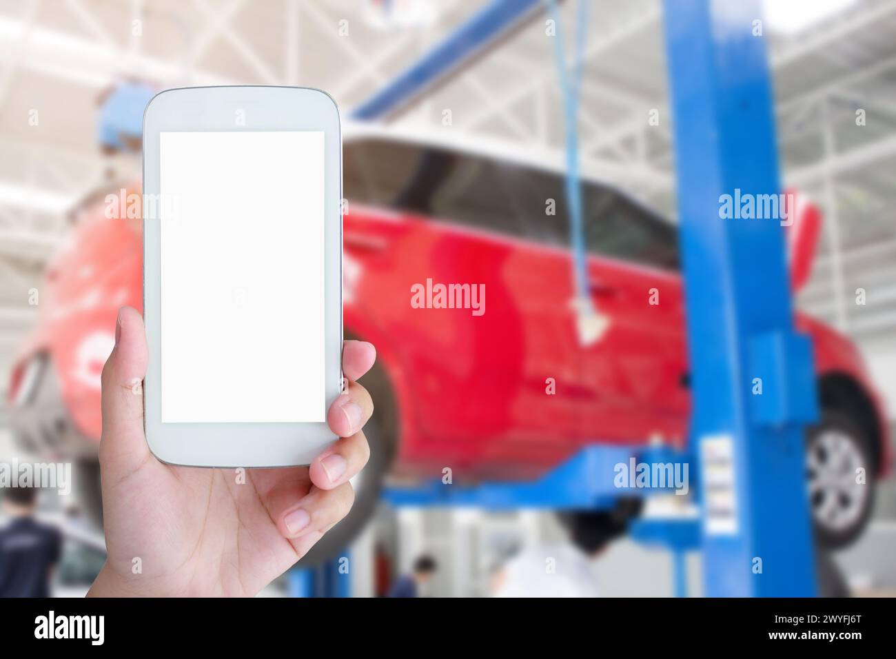 woman hand hold touch screen mobile smart phone with car garage ...