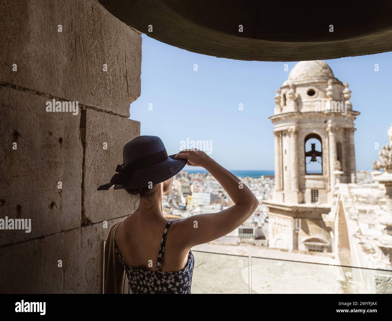 A beautiful young female woman tourist in a sundress and a hat looking ...