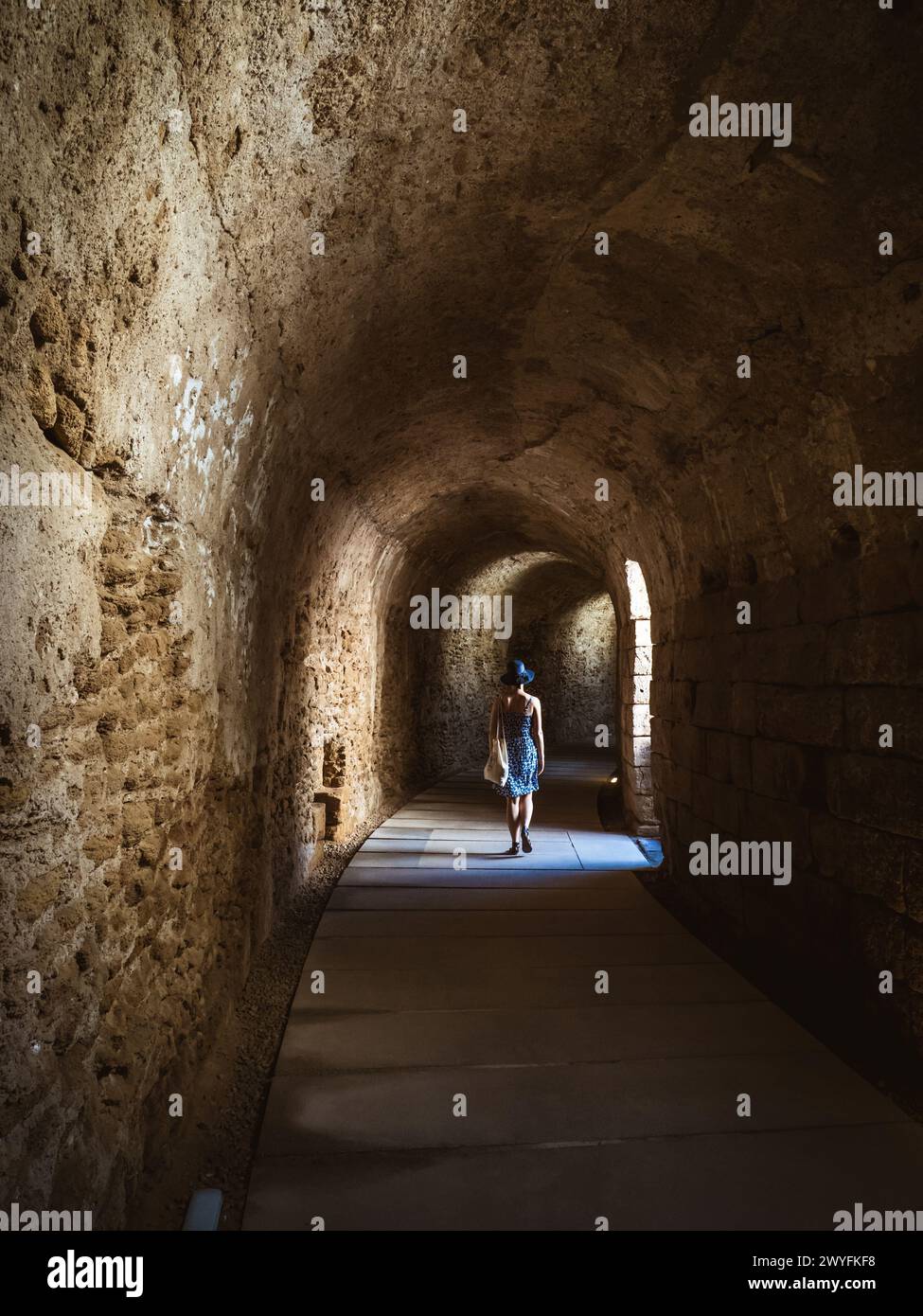 Underground tunnel at the Roman Theatre of Cádiz with a young woman in ...
