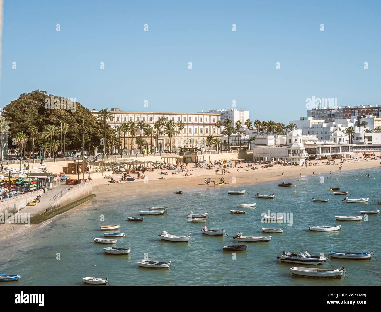 Boats anchored and people sunbathing on a sandy summer beach Playa de ...
