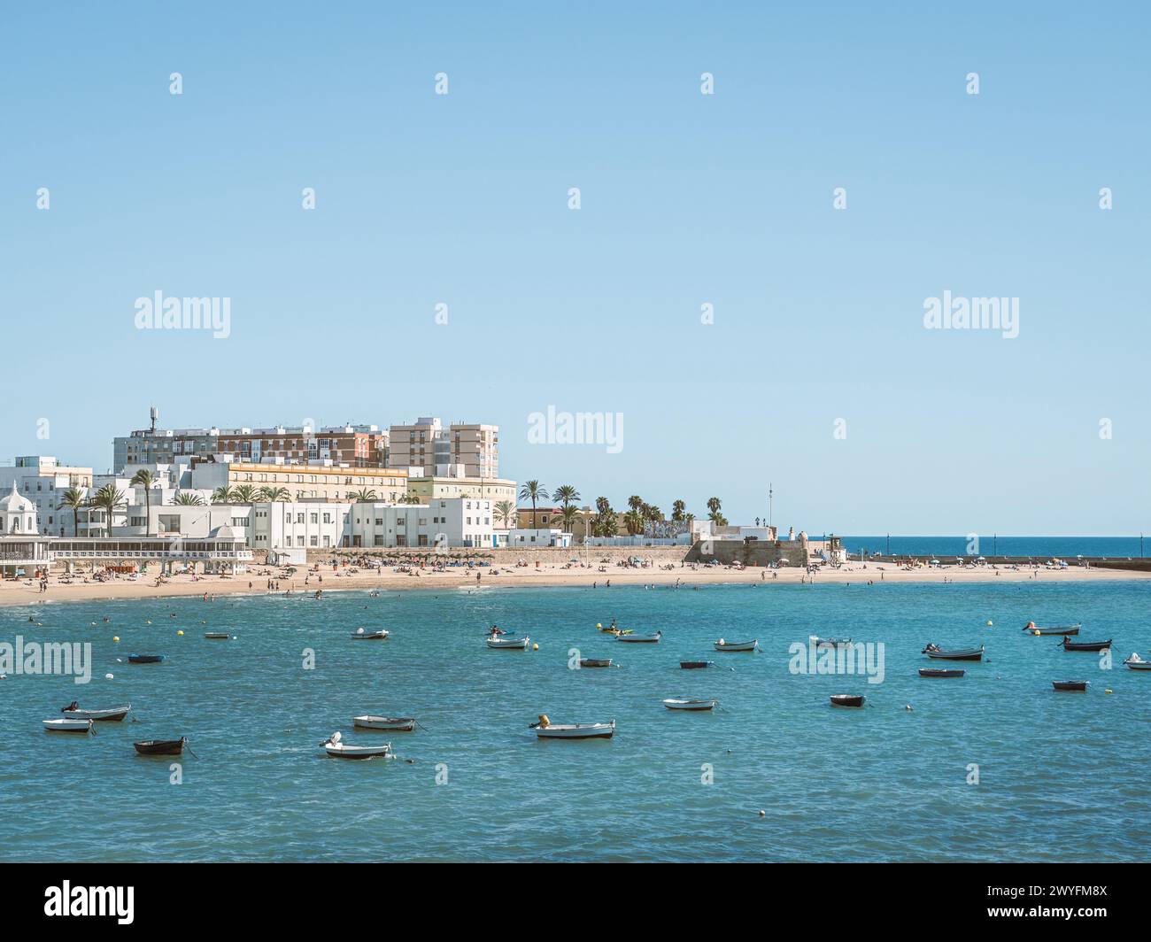Boats anchored and people sunbathing on a sandy summer beach Playa de ...