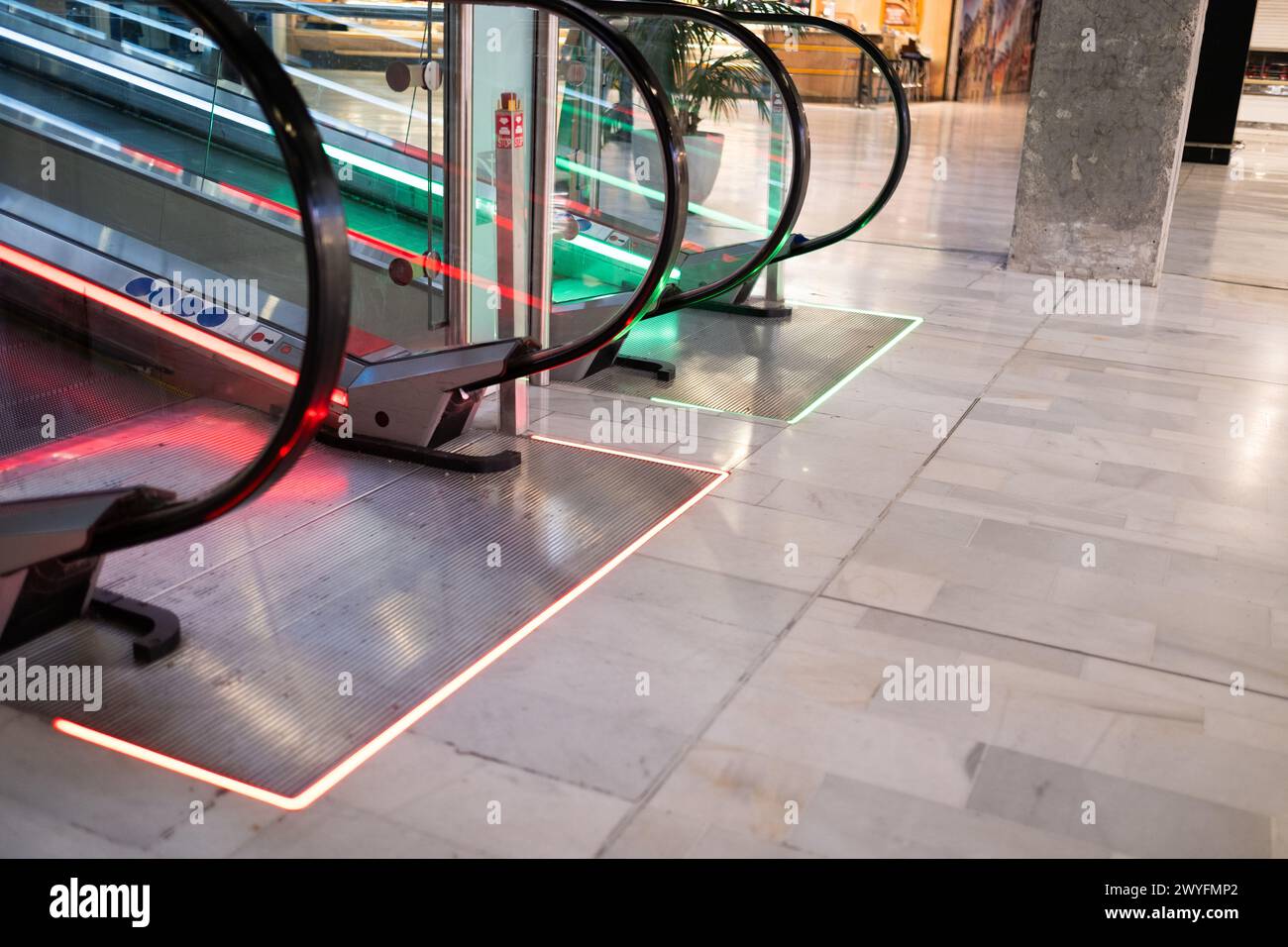 detail of escalator access in a shopping mall. Ascent and descent ...