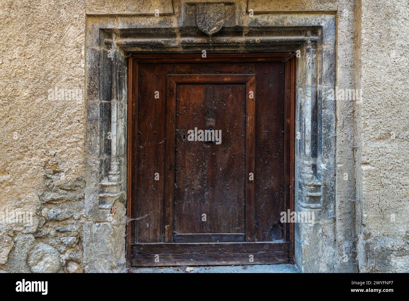 Old wooden door of a typical house of the rustic village of Esterri ...