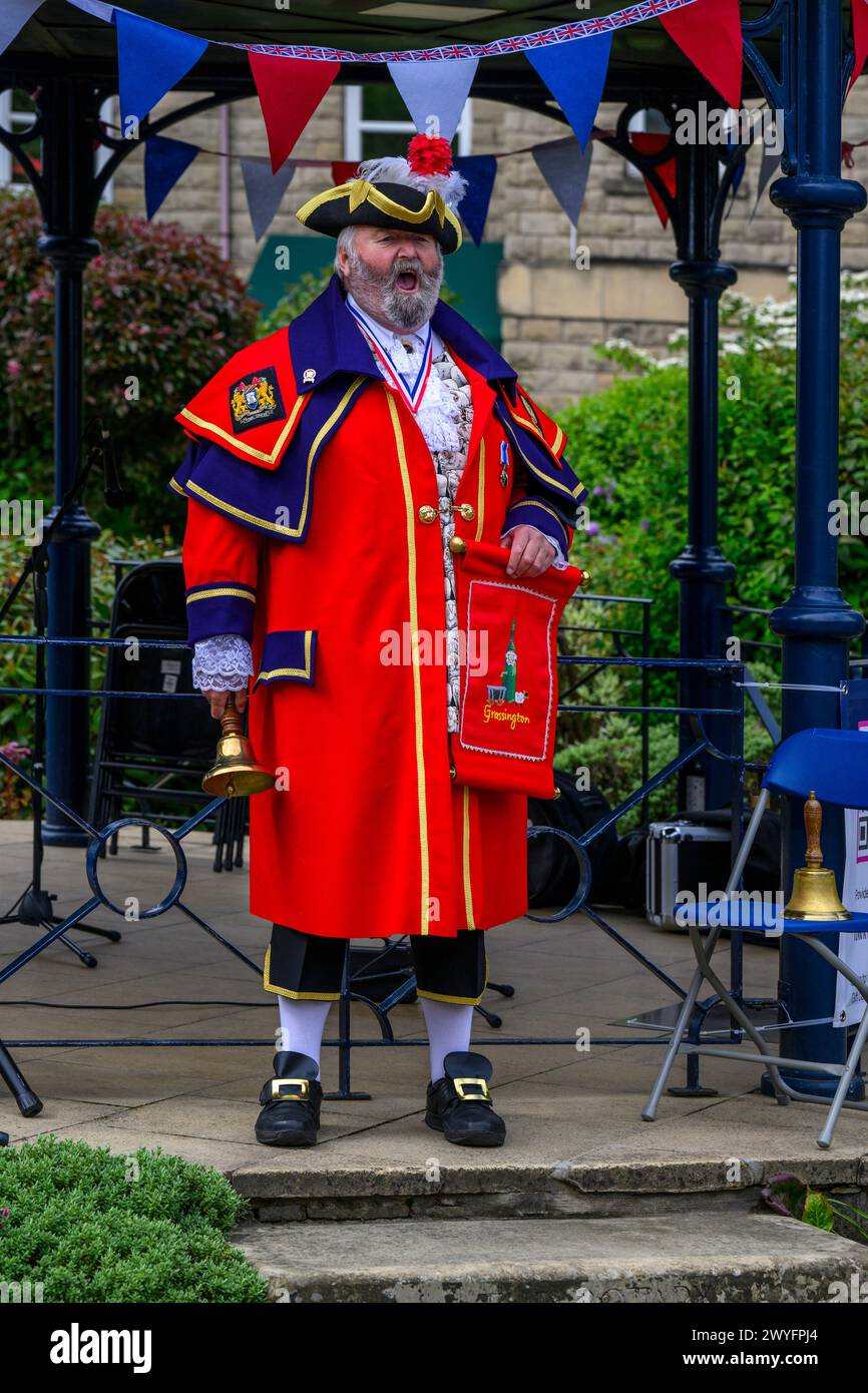 Male town crier (colourful red braided crier's livery) proclaiming ...