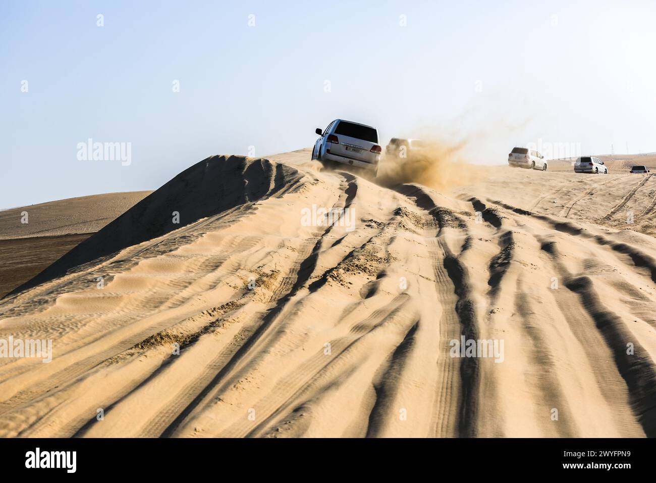 A sports 4wd vehicle speeding through desert sand. Sand spraying around ...