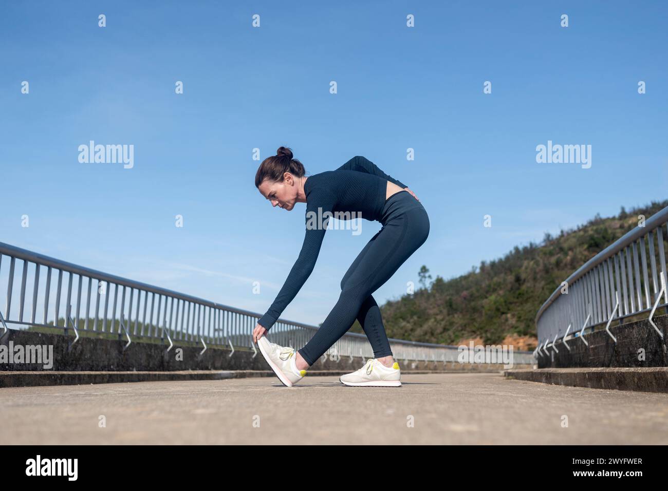 female runner doing warm up leg stretching exercises outside Stock ...