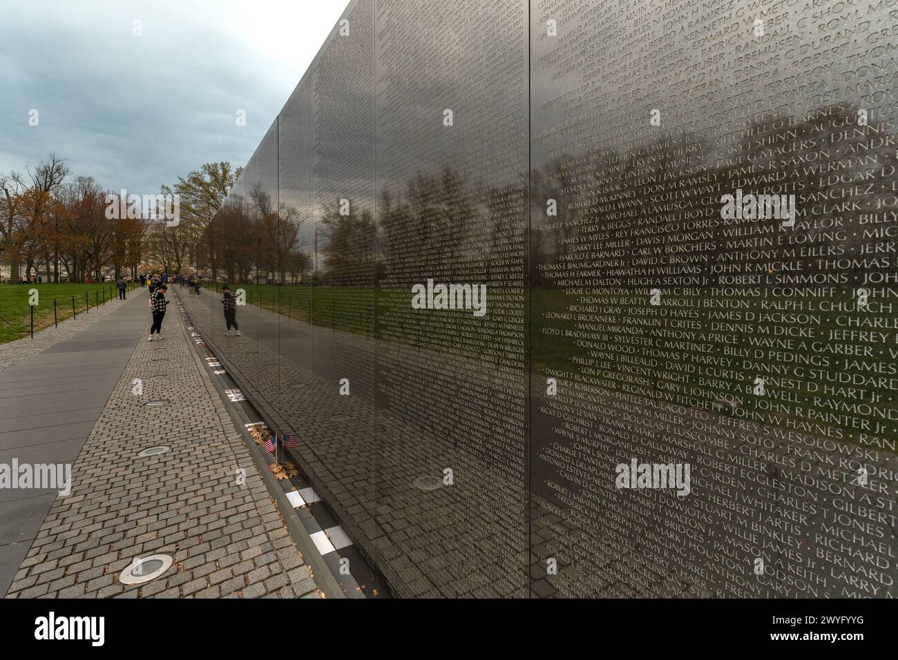 Washington DC - US - Mar 23, 2024 Tourists visiting the Vietnam Veterans Memorial. black granite ...