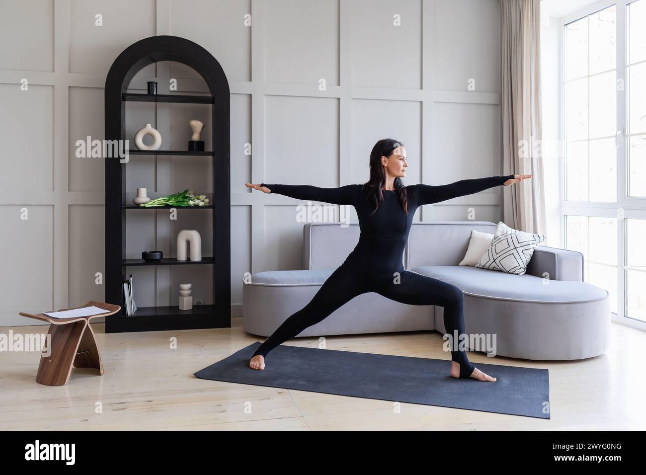 Athletic brunette practicing asanas at home, doing exercise ...