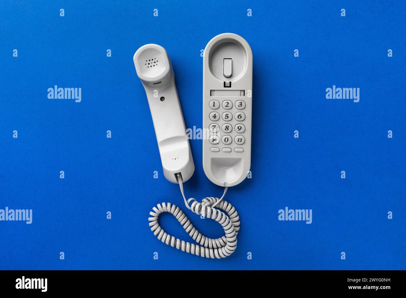 Old corded telephone on a blue background, top view Stock Photo - Alamy