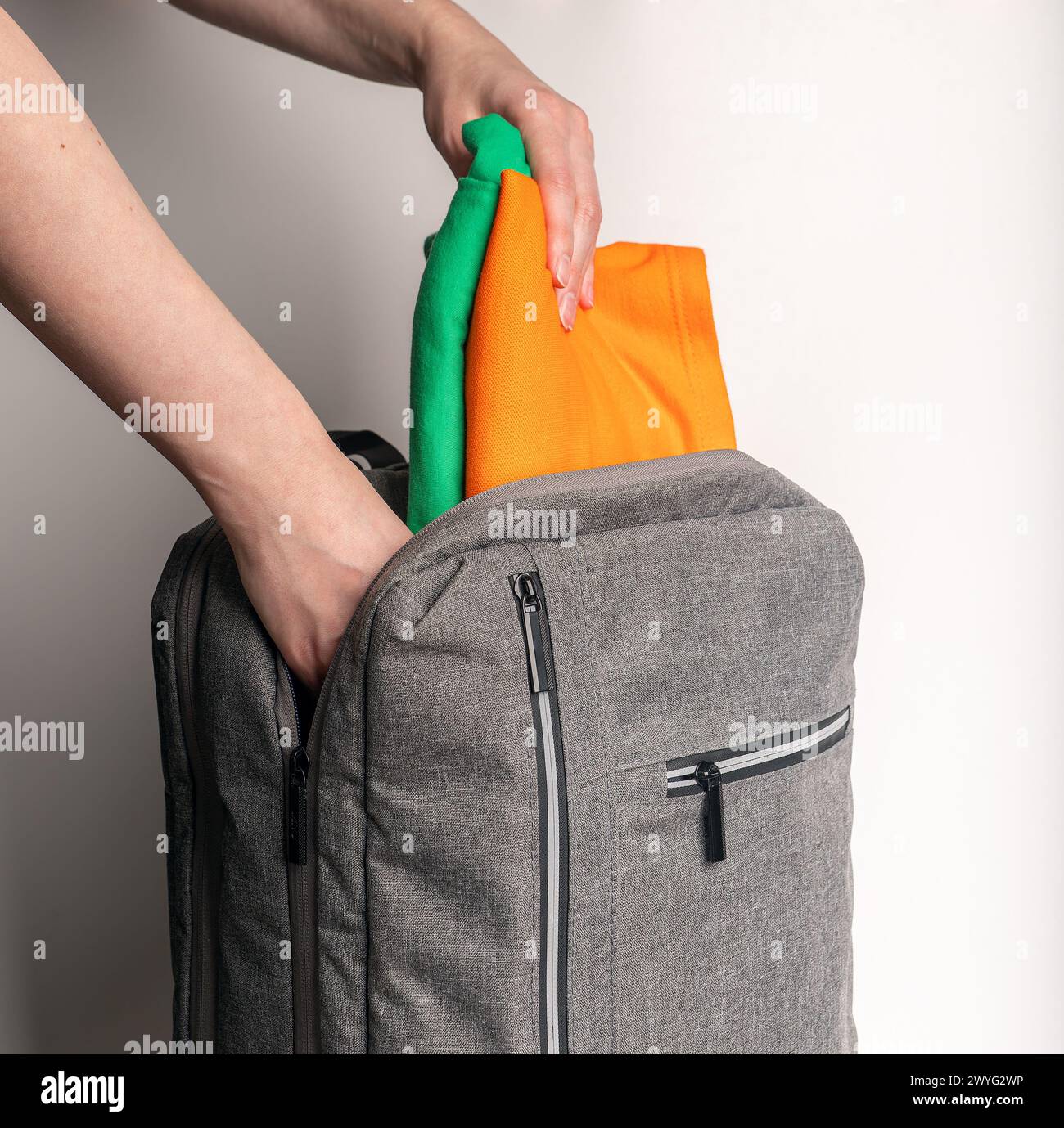 Hands packing clothes into backpack, bag Stock Photo - Alamy