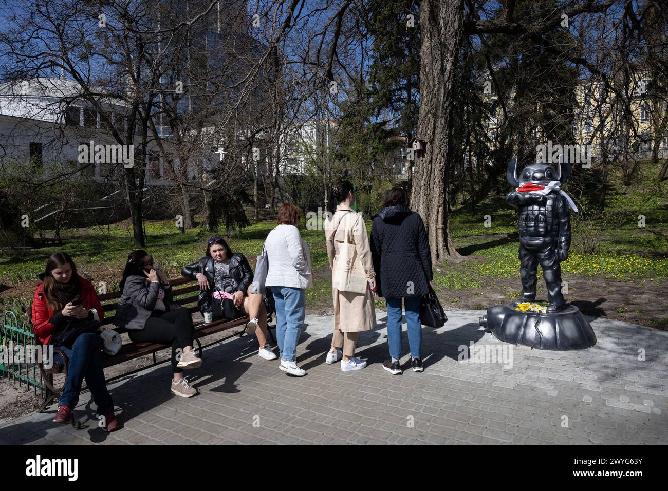 People spend time in the park next to the monument depicting the ...