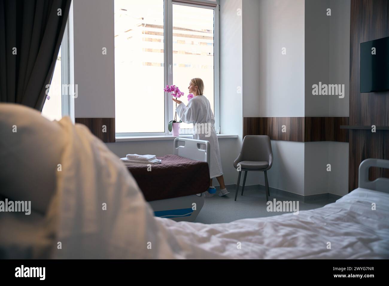 Adult female patient whiling away her time in hospital room Stock Photo ...