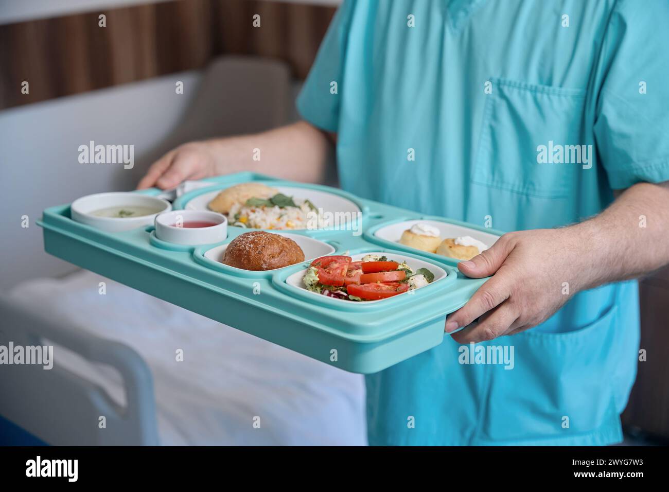 Nursing assistant serving fresh organic food in healthcare facility ...