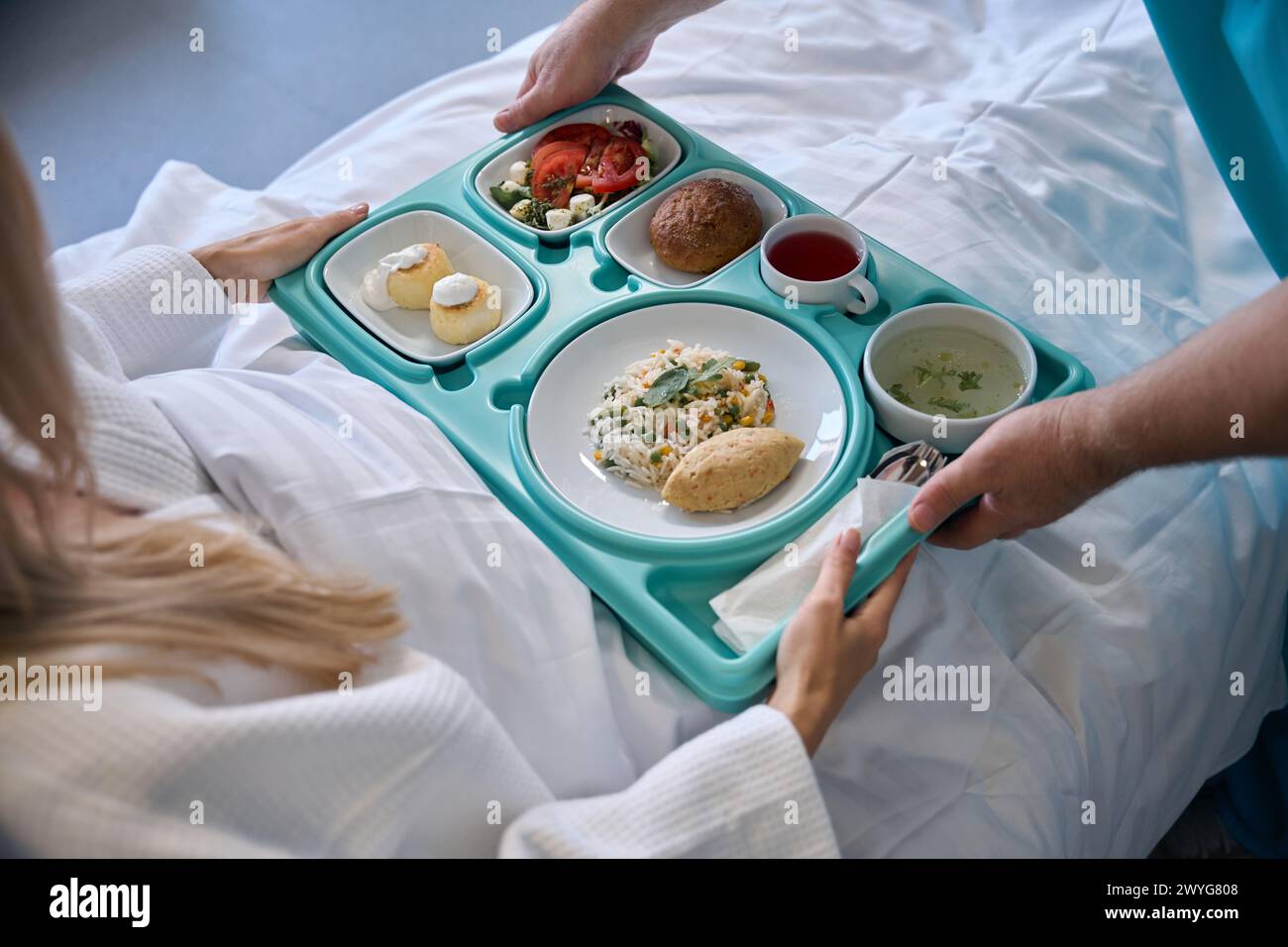 Nursing assistant serving meal to recumbent patient Stock Photo - Alamy