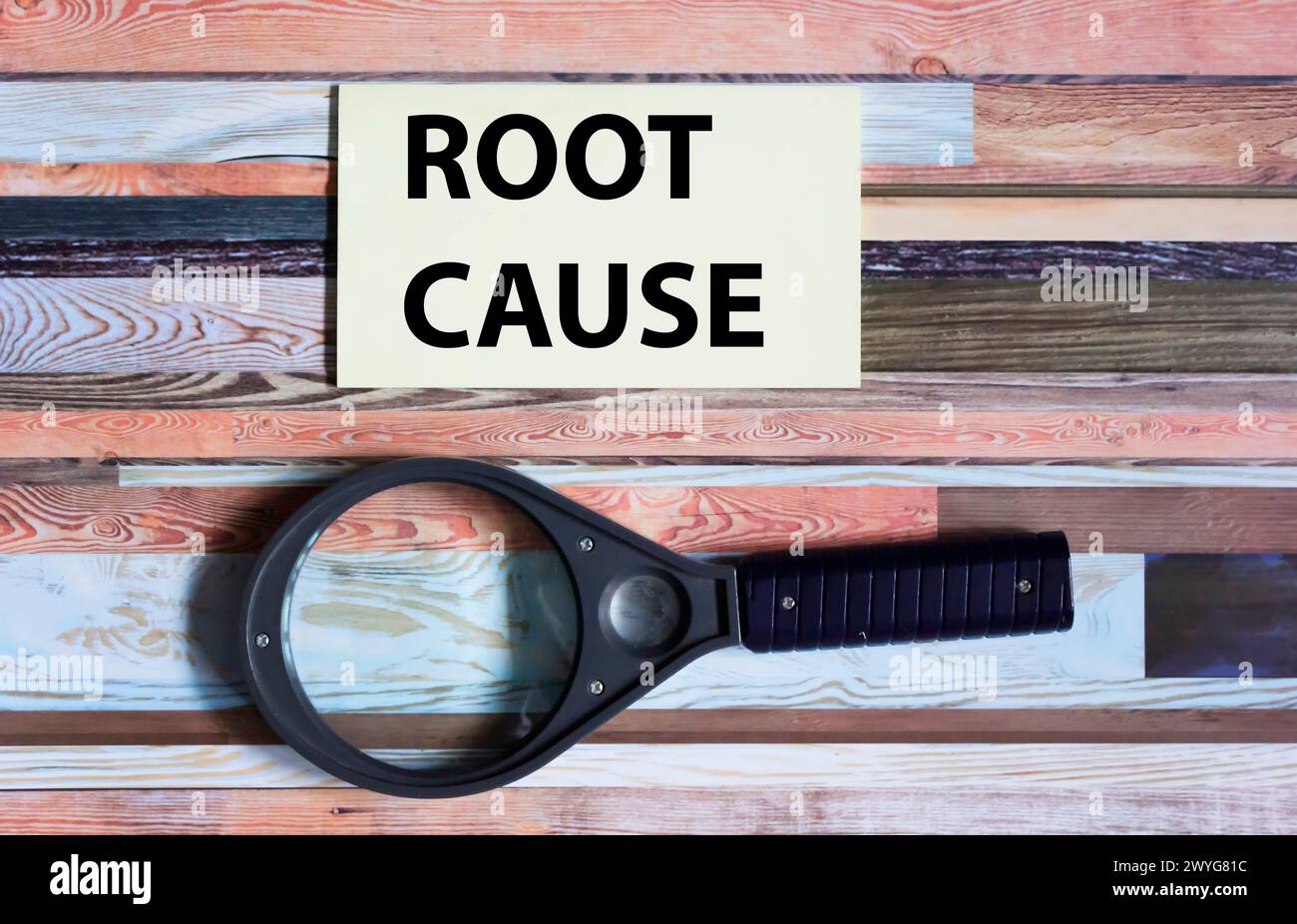 Root cause note text on sticker and vintage background with magnifying ...