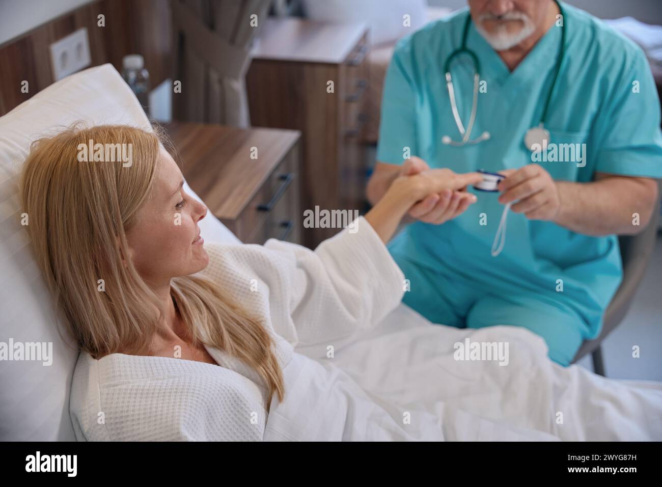 Inpatient blood oxygen saturation level being measured by doctor Stock ...