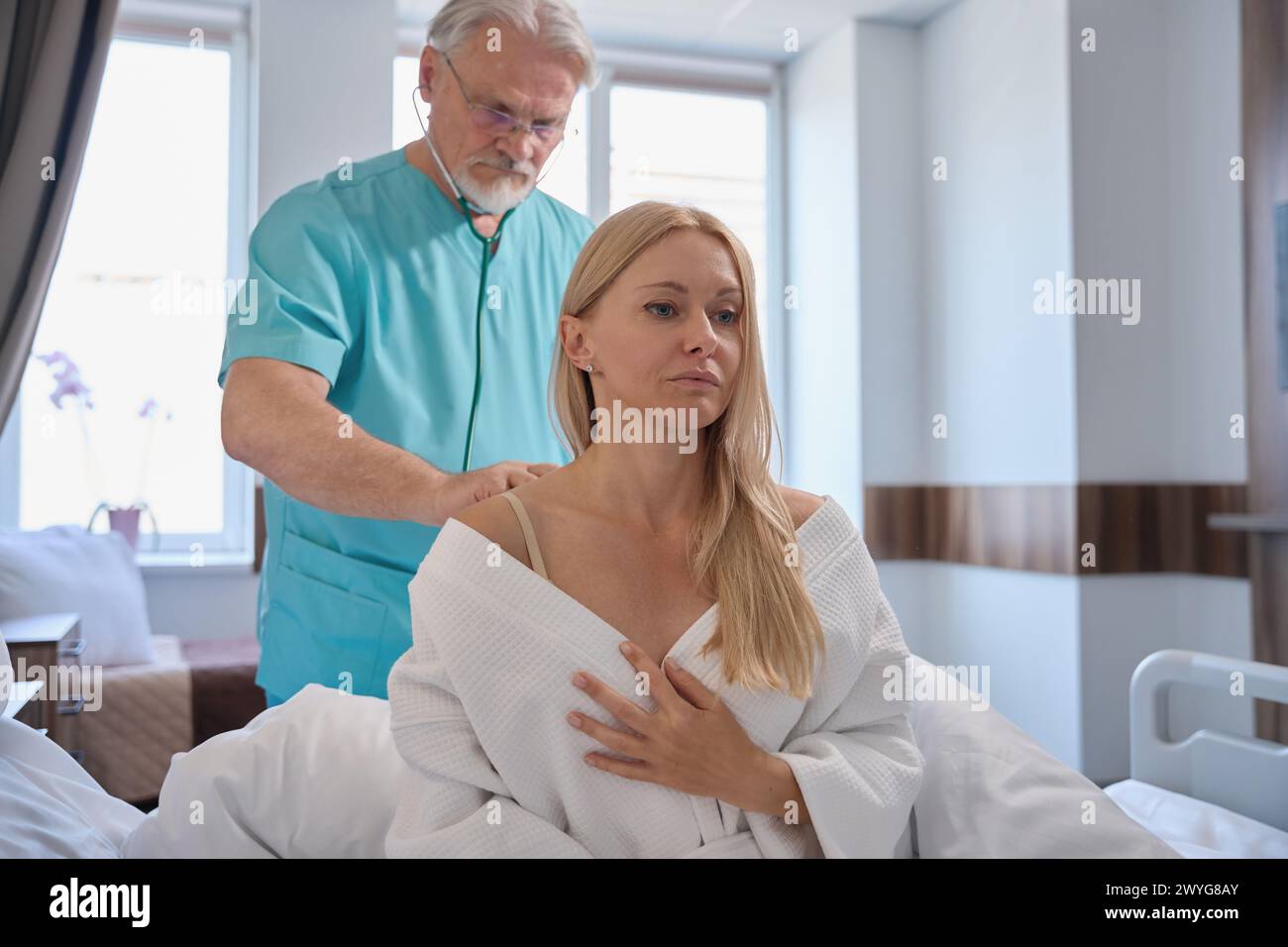 Clinician performing pulmonary auscultation of inpatient during ward ...