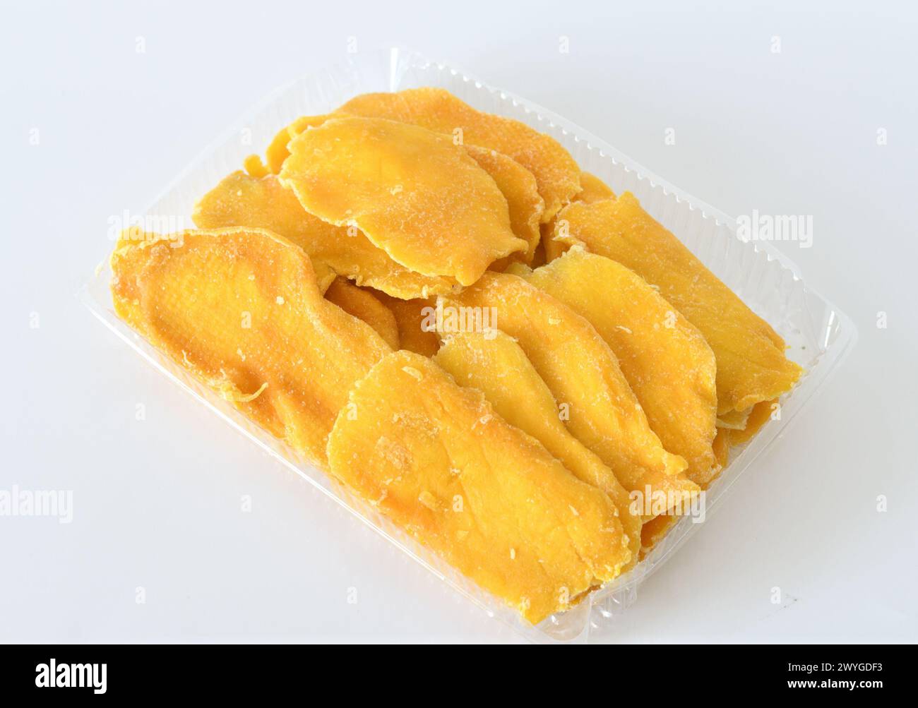 Dry mango in plastic container on a light background Stock Photo - Alamy