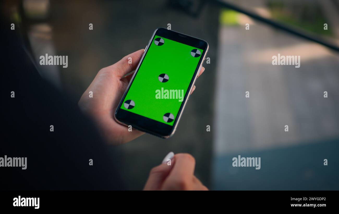 Rear over shoulder view businesswoman using smartphone green screen ...