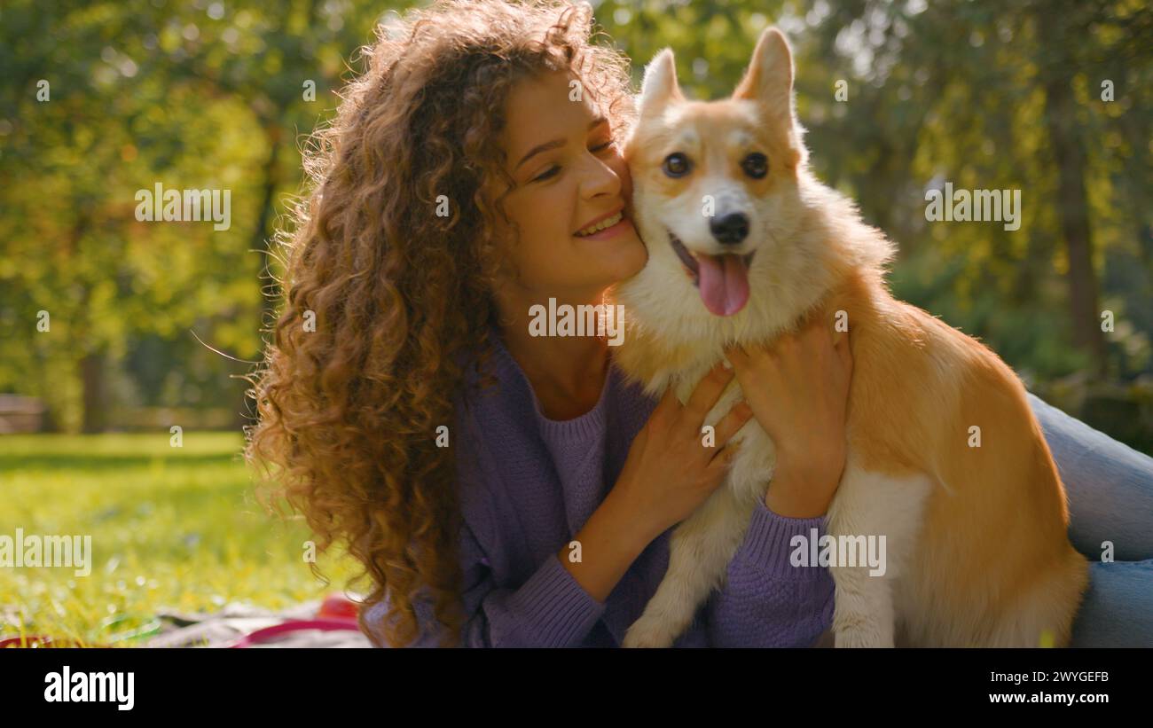Happy woman playing kissing pedigree welsh corgi dog having fun ...