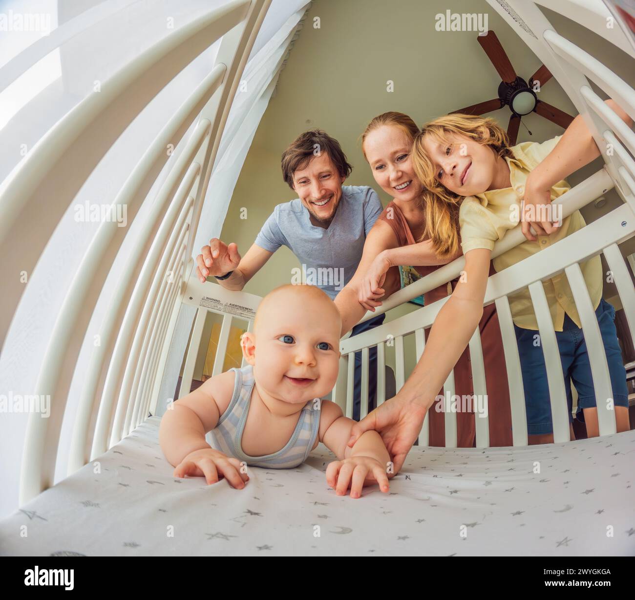Big family with two kids in white bedroom. Parents and kids standing at ...