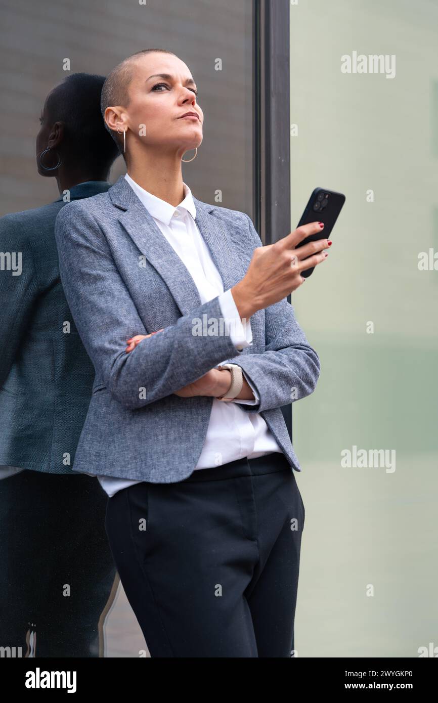 Vertical shot thoughtful Caucasian business woman using an app on her ...