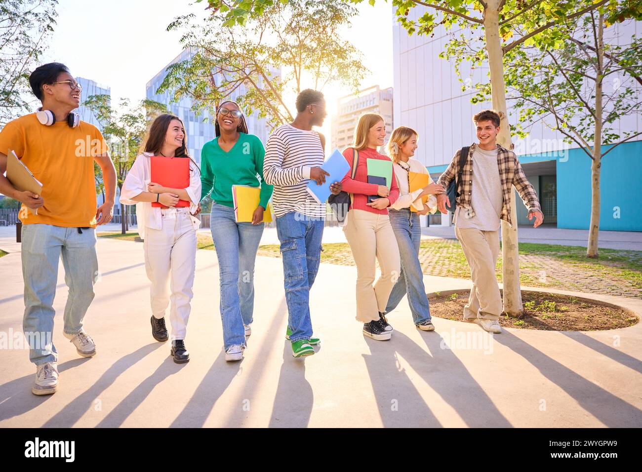 Happy international students walking around the university campus ...