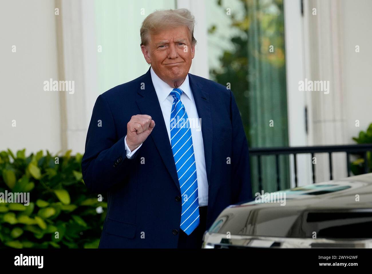 Former President Donald Trump pumps his fist as he arrives for a GOP ...