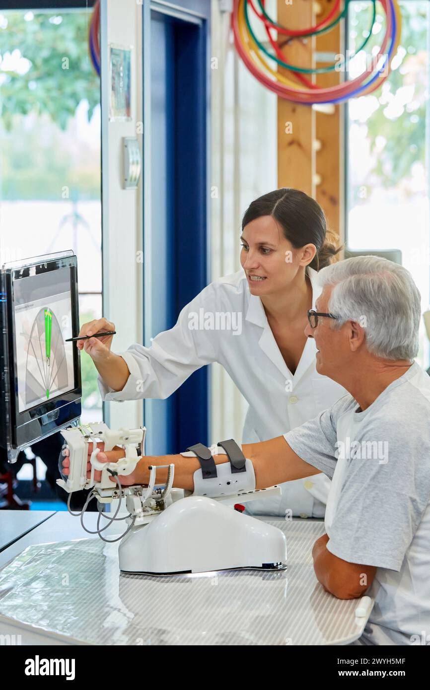 Therapist and patient with assistive robot for upper limb ...