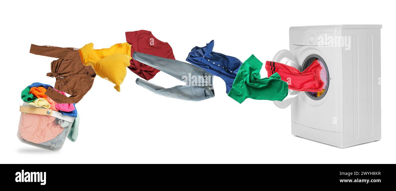 Clothes flying from laundry basket into washing machine on white ...