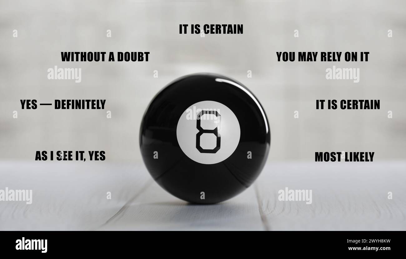 Magic eight ball on white wooden table and positive predictions around ...