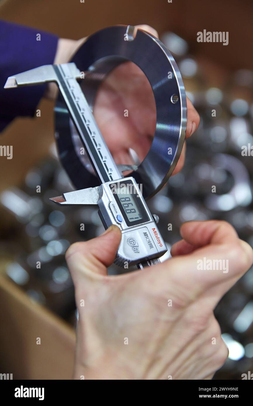 Worker measuring with caliper. Area automated CNC lathes. Machined ...